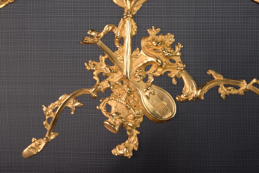 Pare étincelle de style Louis XV en bronze doré décoré d'instruments de ...